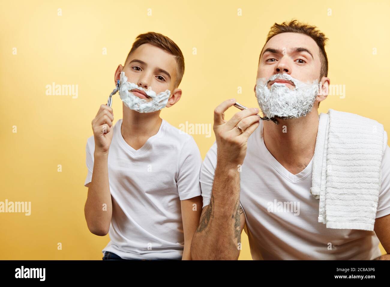 bearded Father and son shaving on yellow background Stock Photo - Alamy