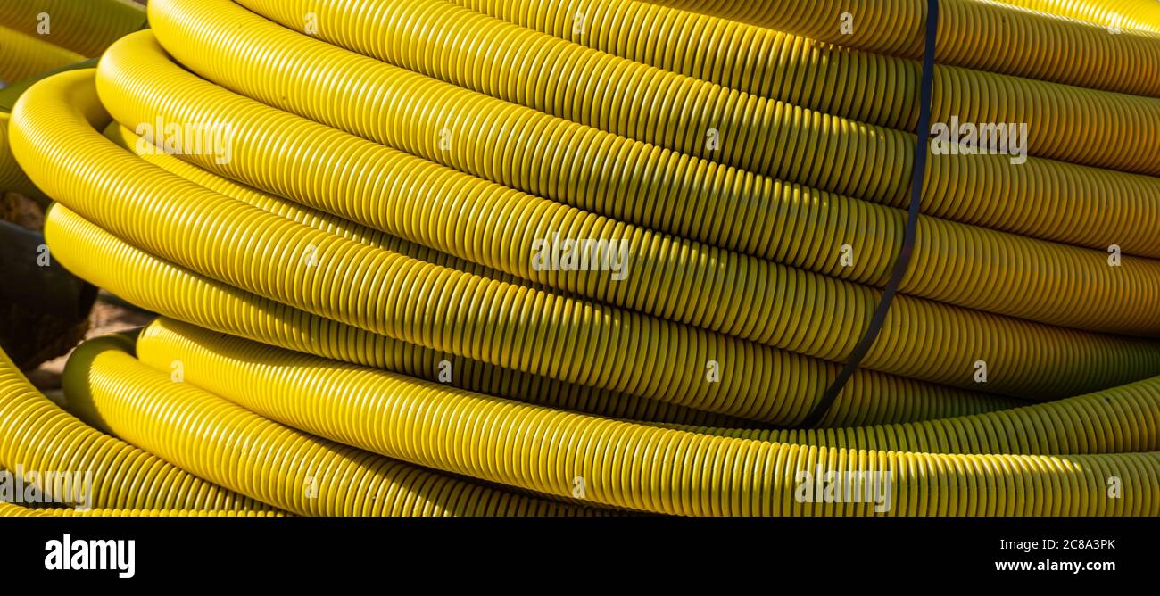 Large roll of yellow flexible pipe at a building site Stock Photo - Alamy