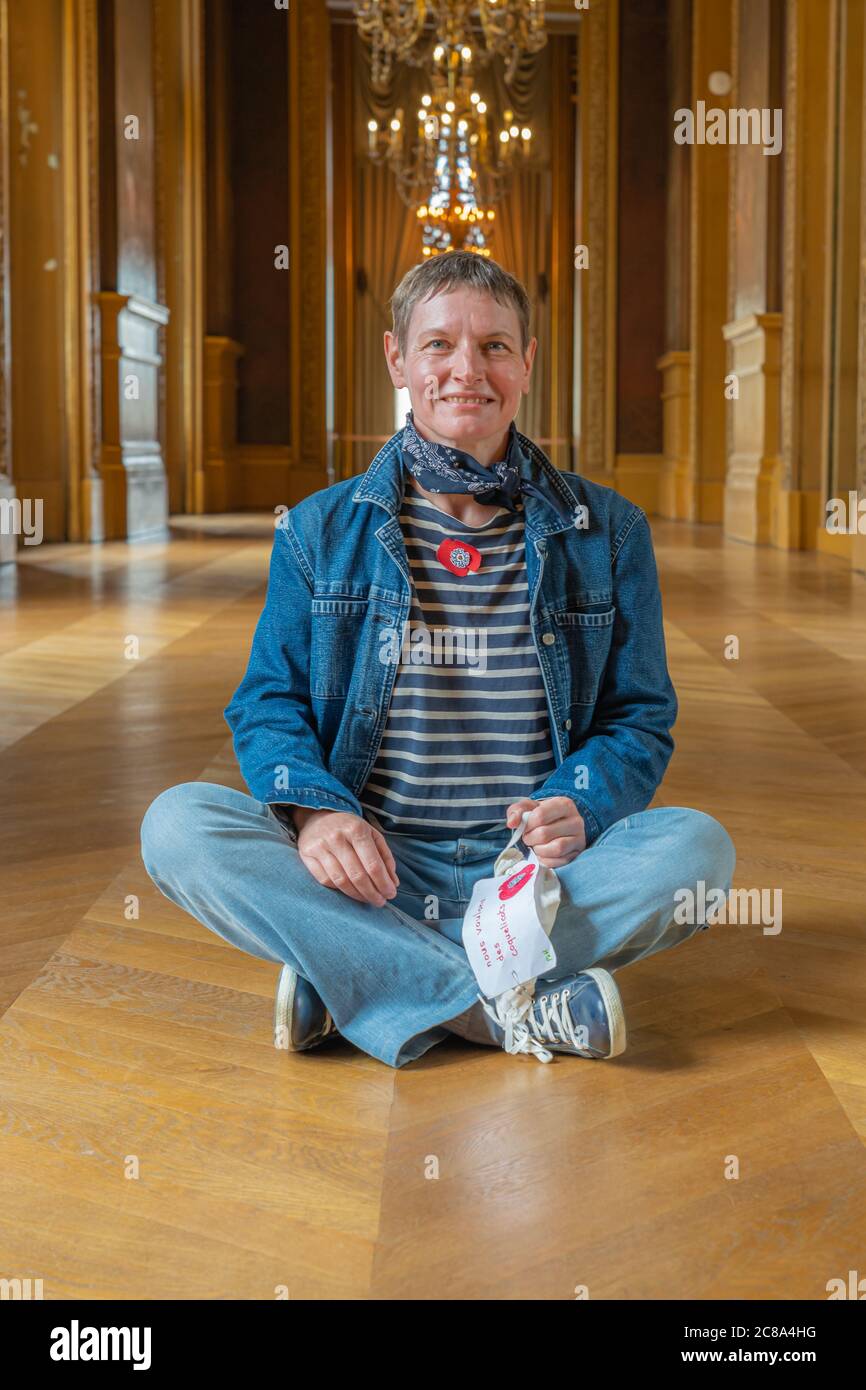 Paris, France - 06 19 2020: A masked woman sitting on the wooden floor ...