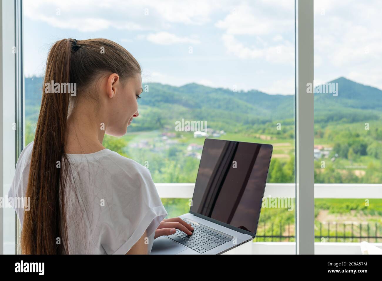 Cute smiling woman using laptop at home. Student girl working on ...