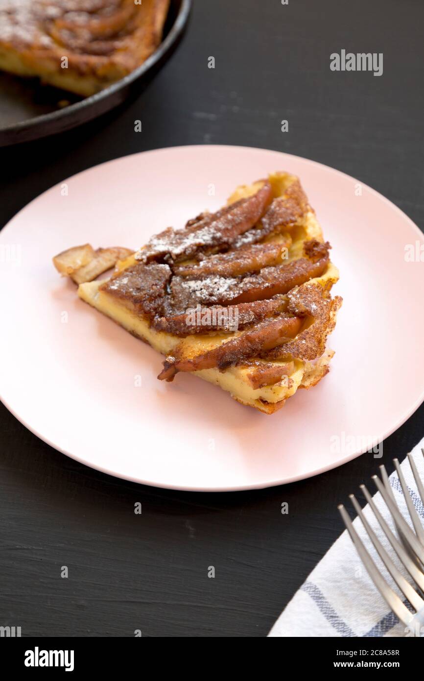 Homemade Apple Dutch Pannekoek Pancake on a pink plate on a black ...