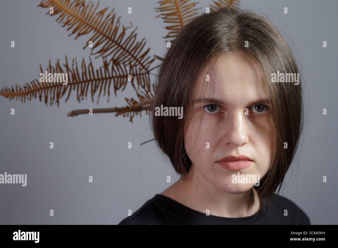 Stylish portrait of brunette girl with crown of fern in her hair, gray ...