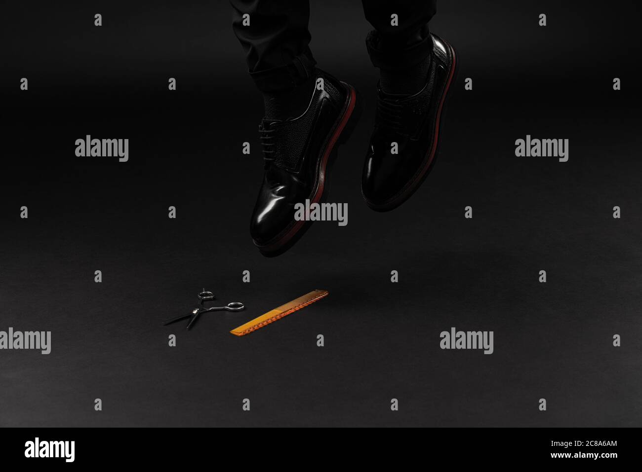 Flying leather shoes under hairdresser tools comb, scissors over black ...