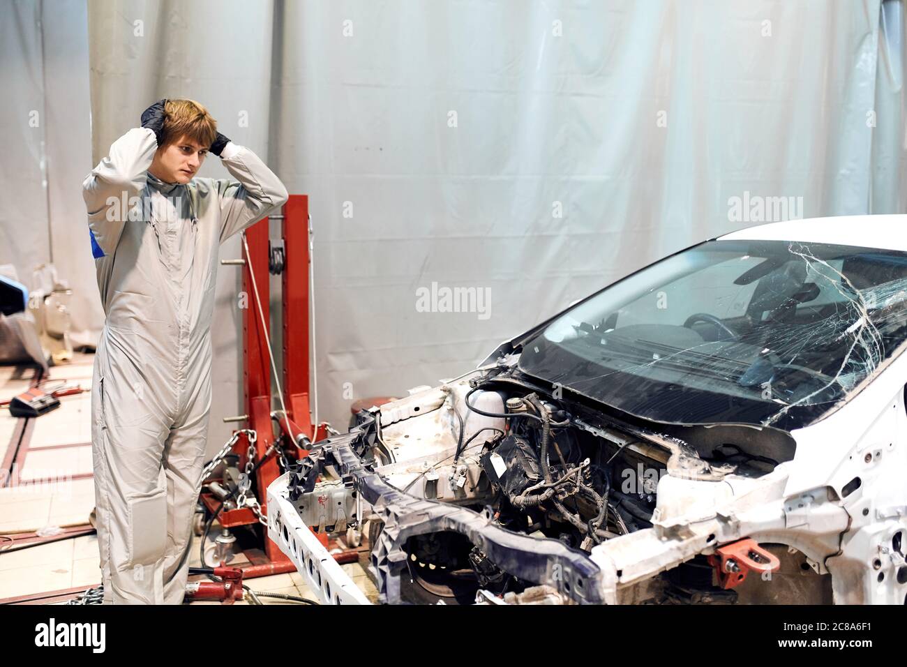 frustrated stressed mechanic man in white uniform holding head against ...