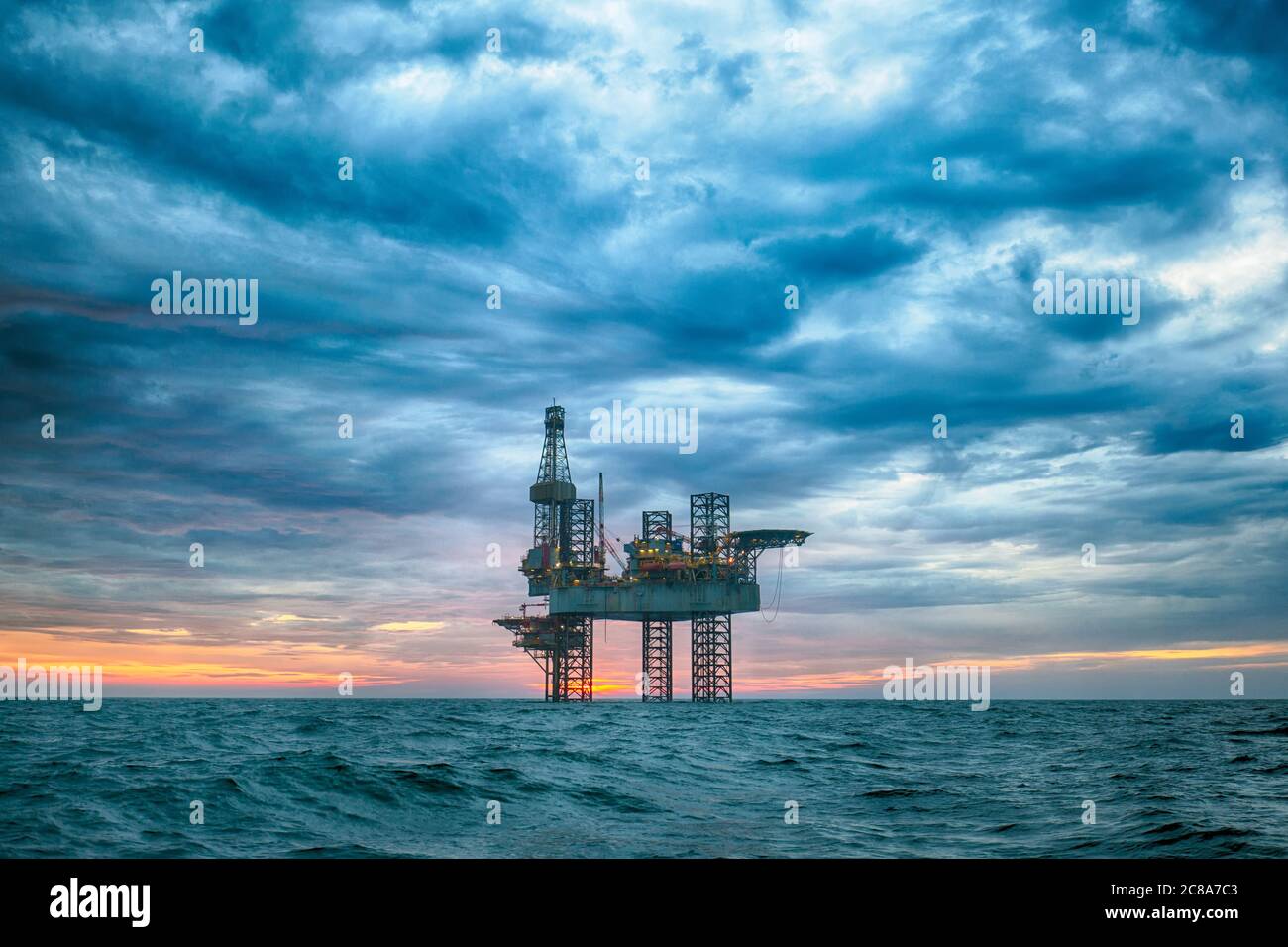 Oil rig at sunset time Stock Photo - Alamy