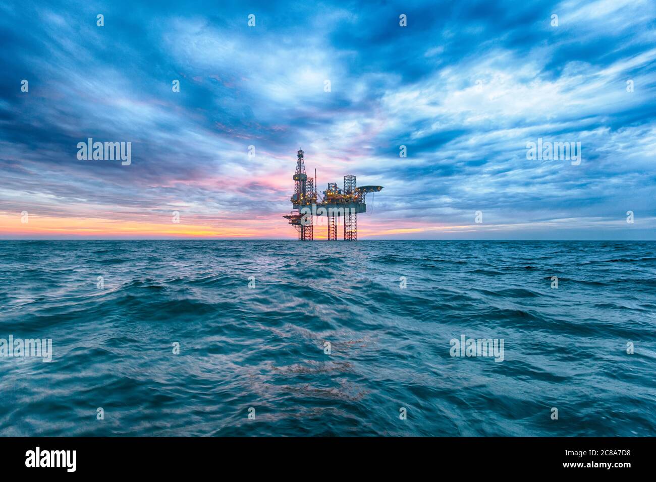 Oil rig at sunset time Stock Photo - Alamy