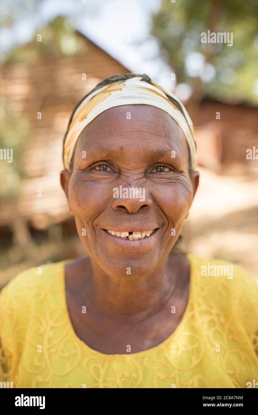 Portrait of a smiling African woman in yellow - Makueni County, Kenya ...