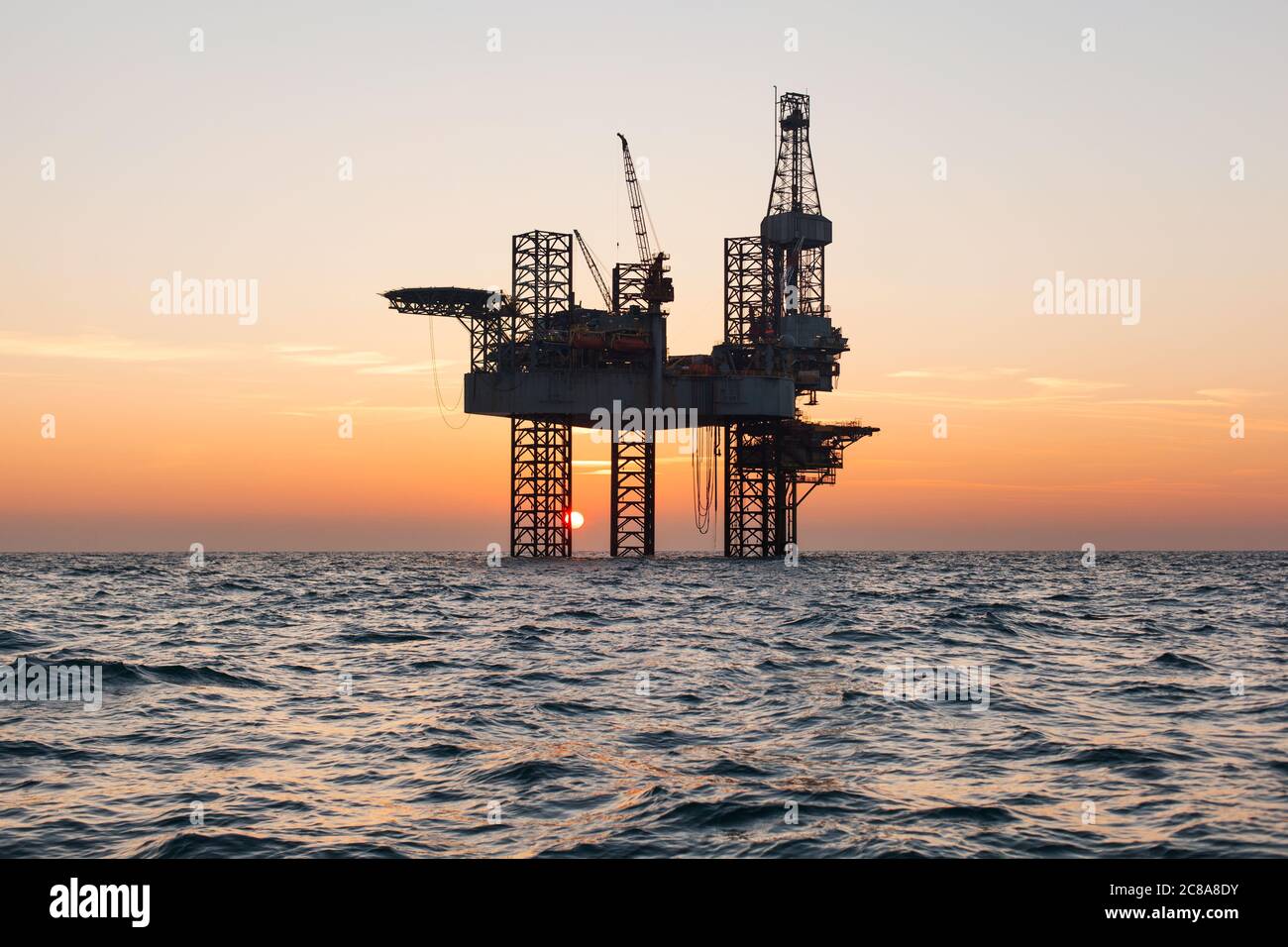 Oil rig at sunset time Stock Photo - Alamy