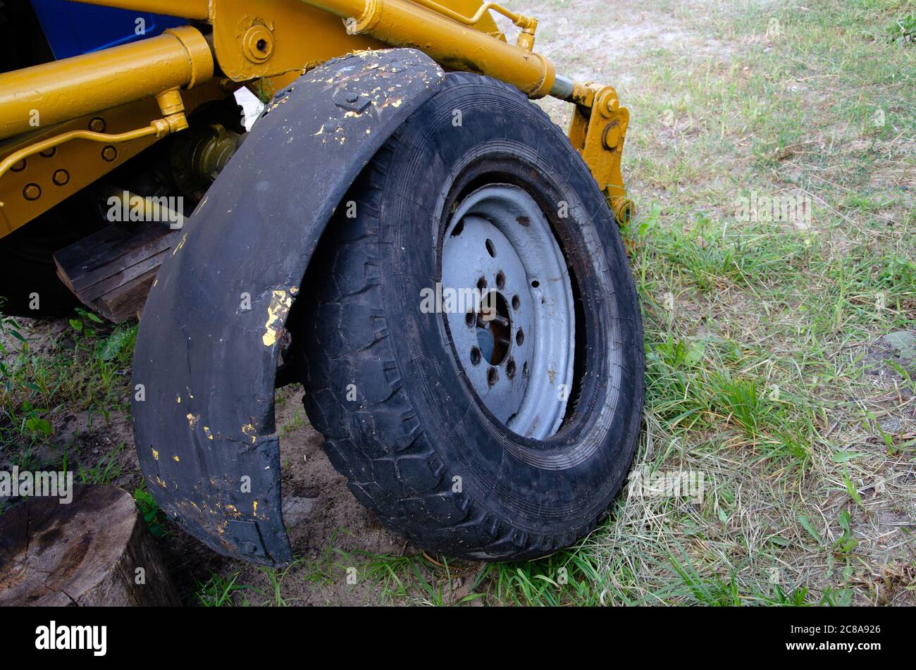 Old rusty tractor's flat back tire. industrial Stock Photo - Alamy