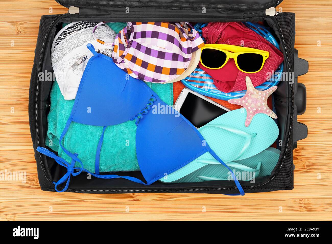 open suitcase on floor with beach accessories, top view Stock Photo - Alamy