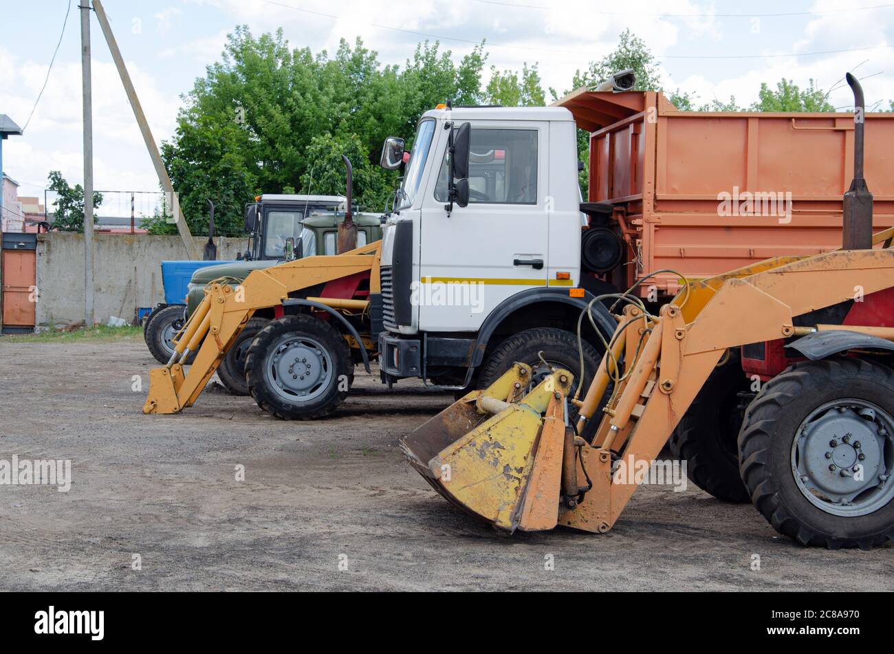 Multiple cars, trucks, loaders, concrete mixers and construction ...