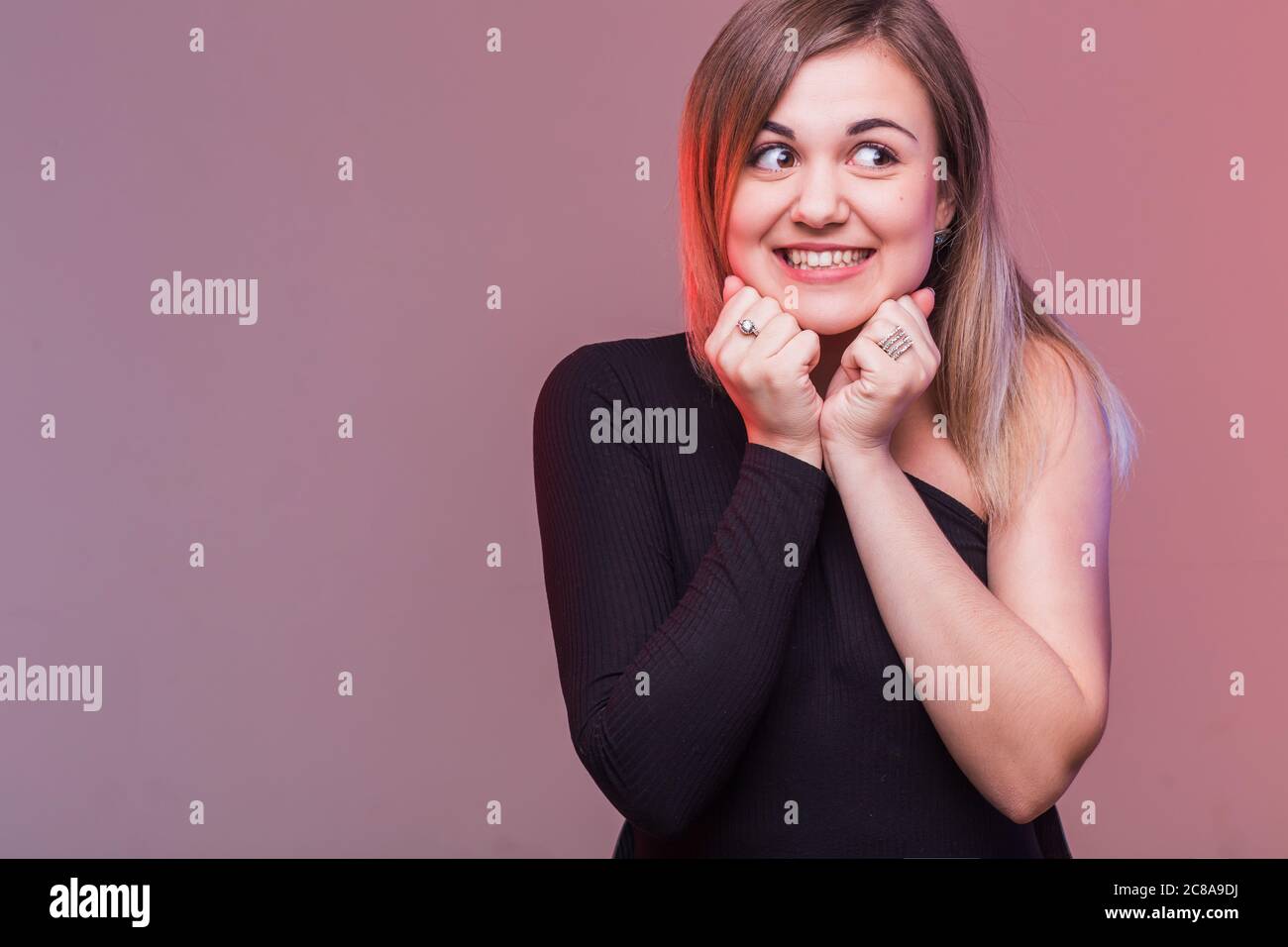 Happy cheerful young woman rejoicing at positive news or birthday gift ...