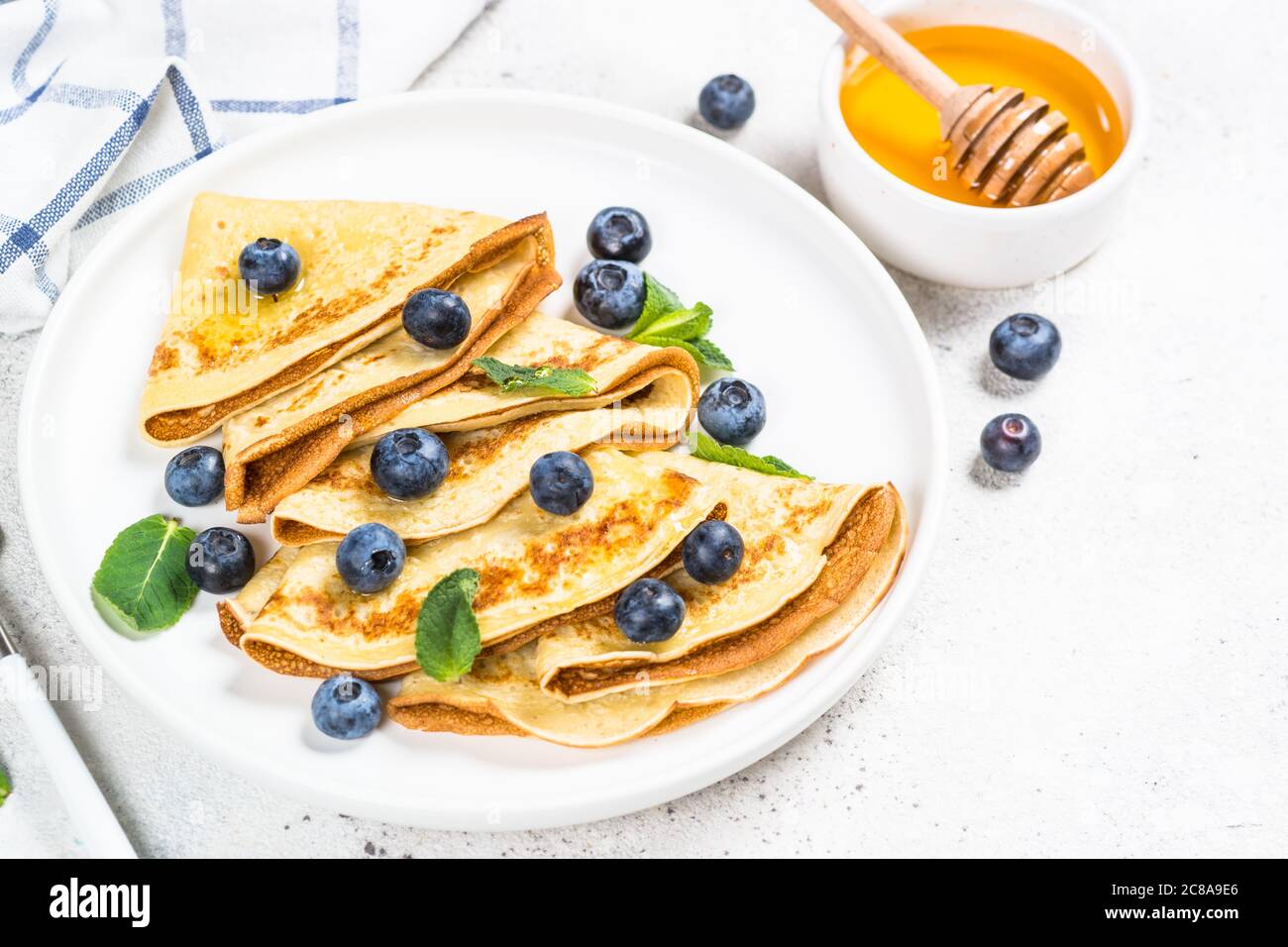 Crepes with blueberries at white table Stock Photo - Alamy