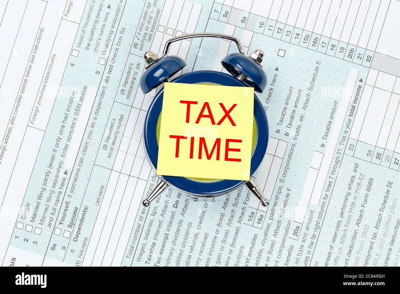 tax concept with yellow note on alarm clock on 1040 form Stock Photo ...