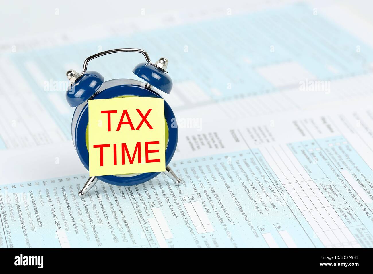 tax concept with yellow note on alarm clock on 1040 form Stock Photo ...