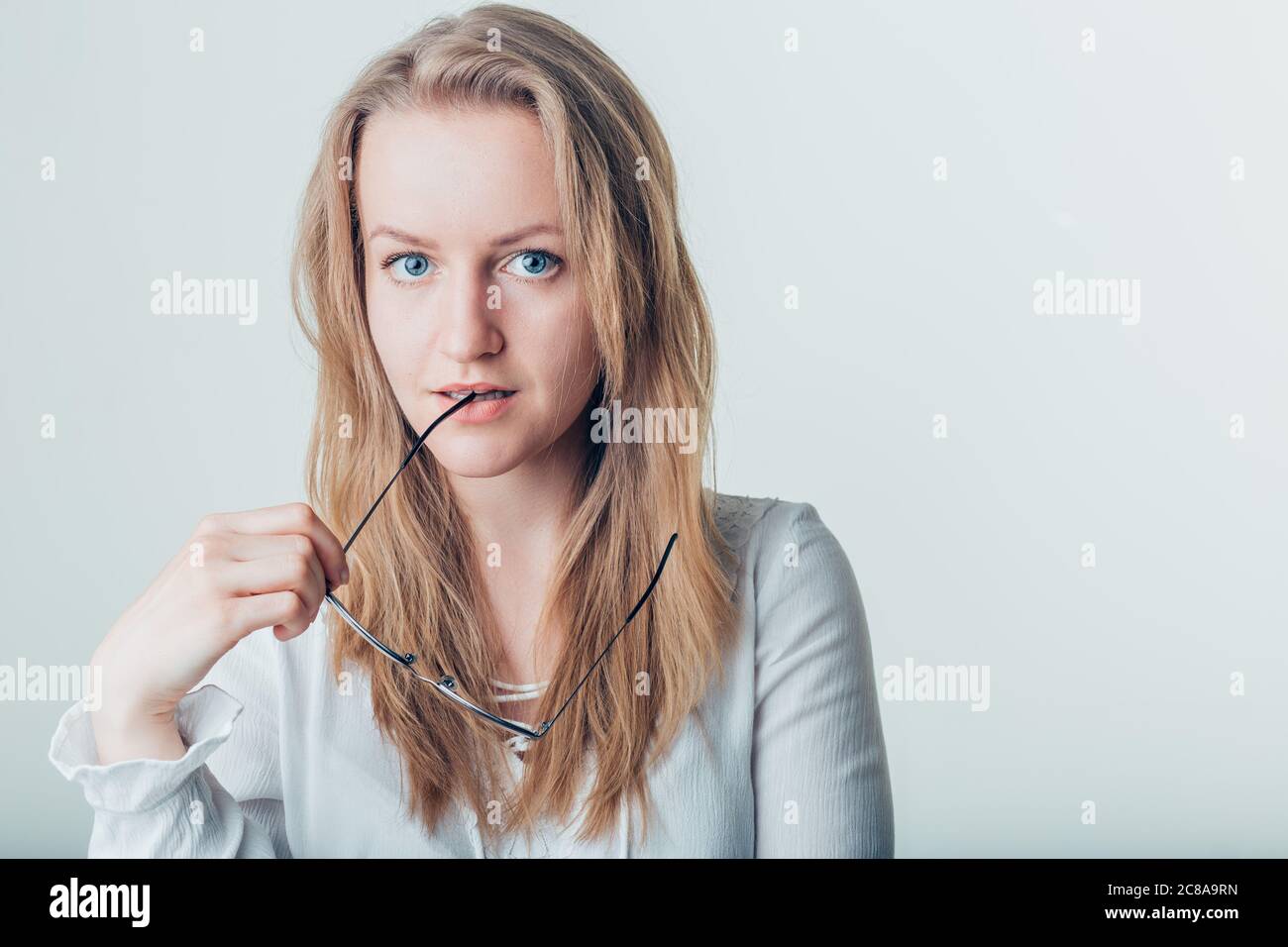 Beautiful woman biting glasses hi-res stock photography and images - Alamy