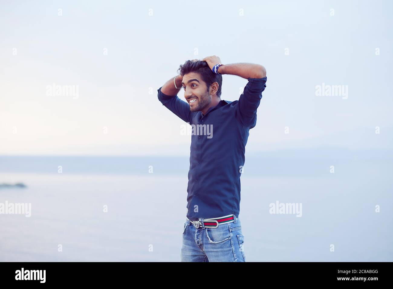 Angry Man pulling hair out of his head while standing on a shore above ...