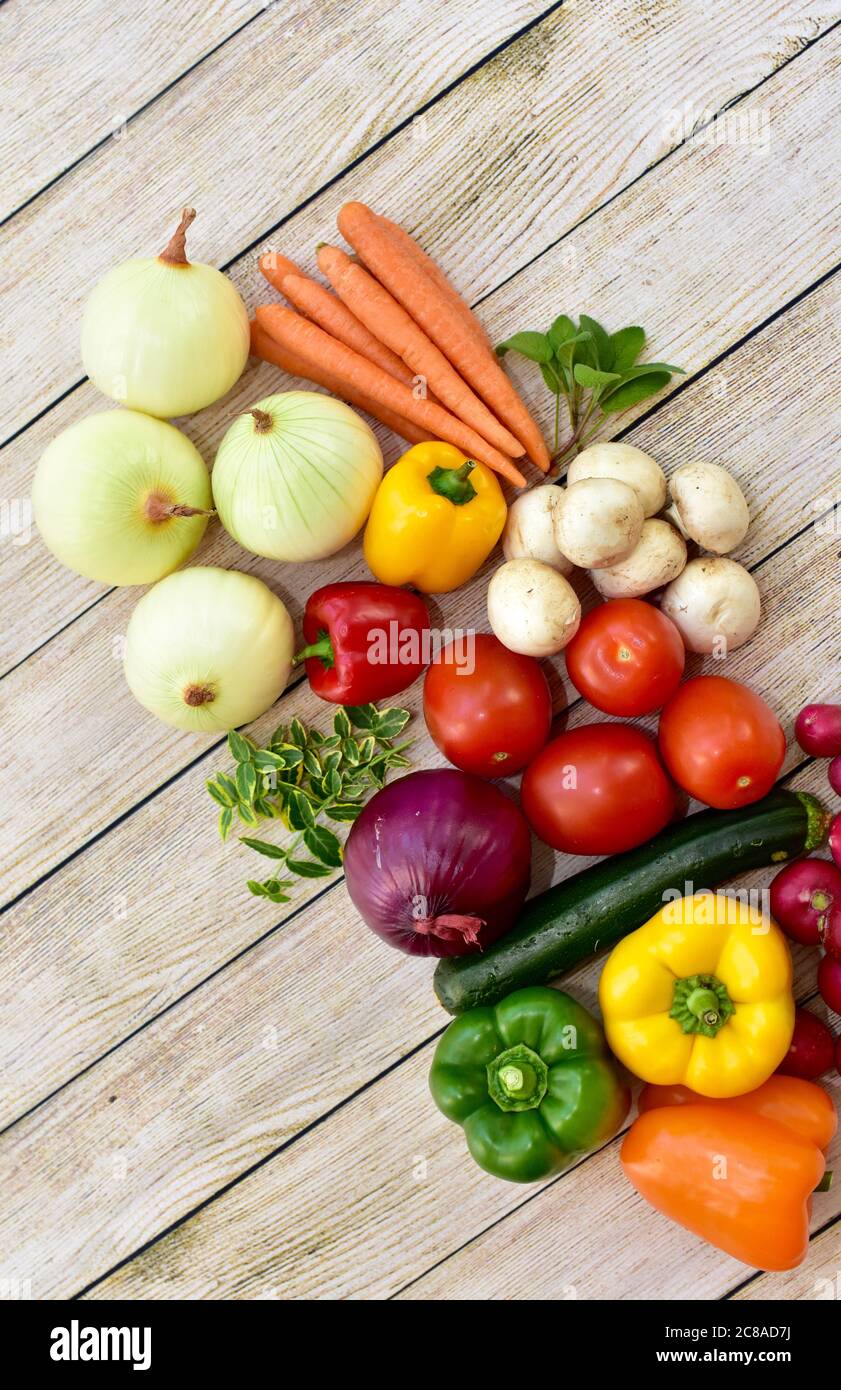 Fresh organic harvested vegetables and flowers displayed on wooden ...