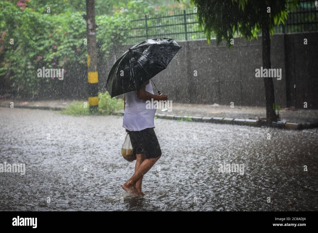 A man uses an umbrella to protect himself from the rain.Heavy rain hits ...