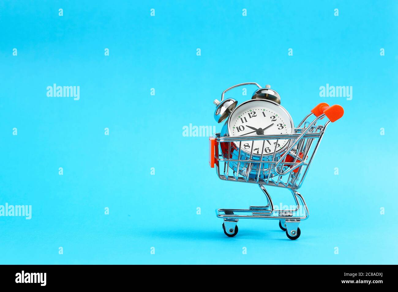 shopping cart with alarm clock on blue, buying time concept Stock Photo ...