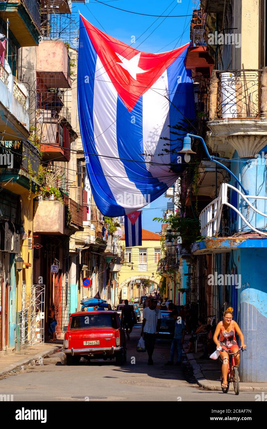 Urban scene with cuban flags, people and aged buildings in Old Havana ...