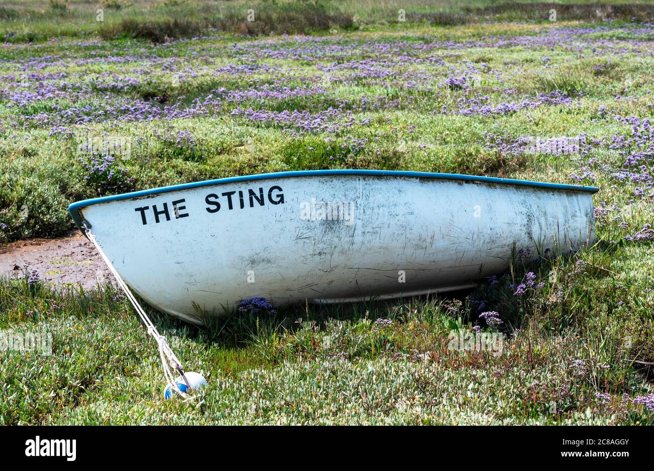 Morston Quay, Norfolk, UK. Small fibreglass tender The Sting moored ...
