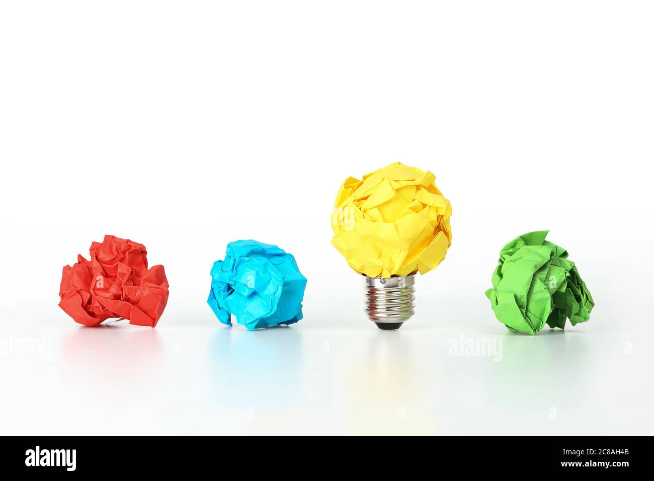 crumpled paper light bulb among other crumpled paper balls, idea or ...