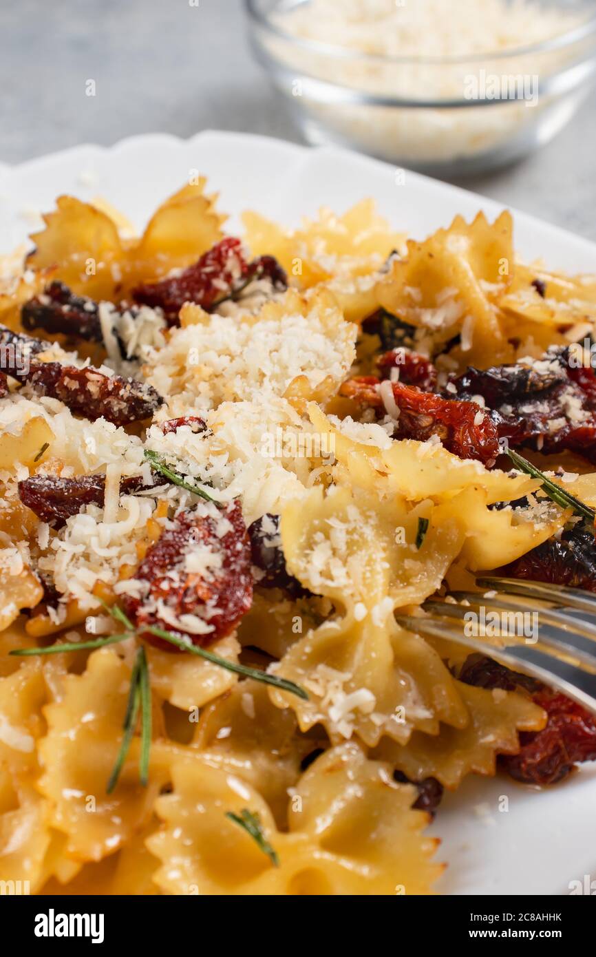 Pasta with sun dried tomatoes and parmesan in a white plate on the ...