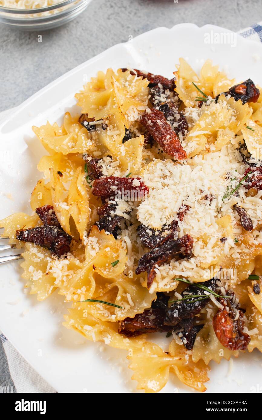 Pasta with sun dried tomatoes and parmesan in a white plate on the ...