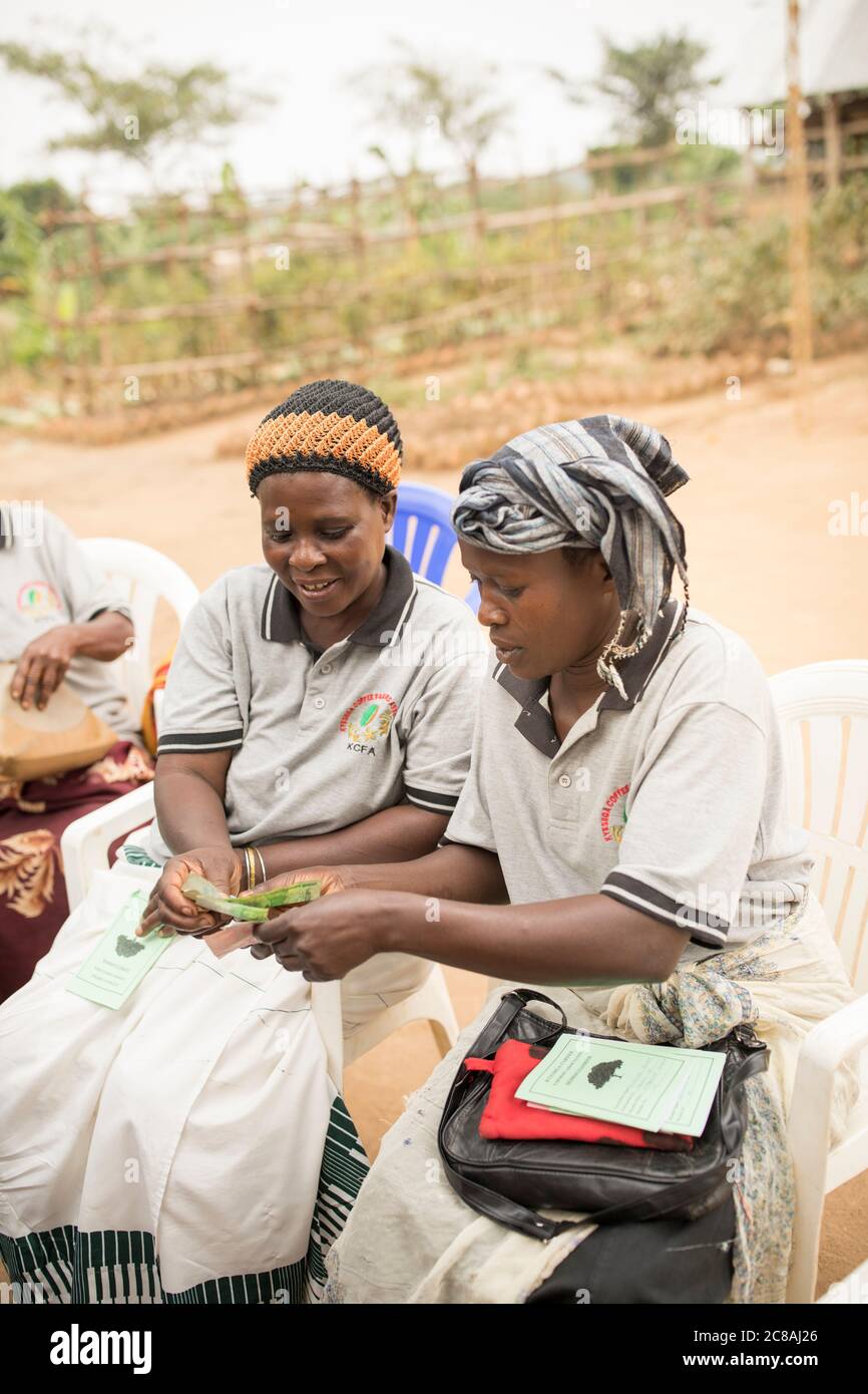 Women in a microfinance community banking group meet together to save ...