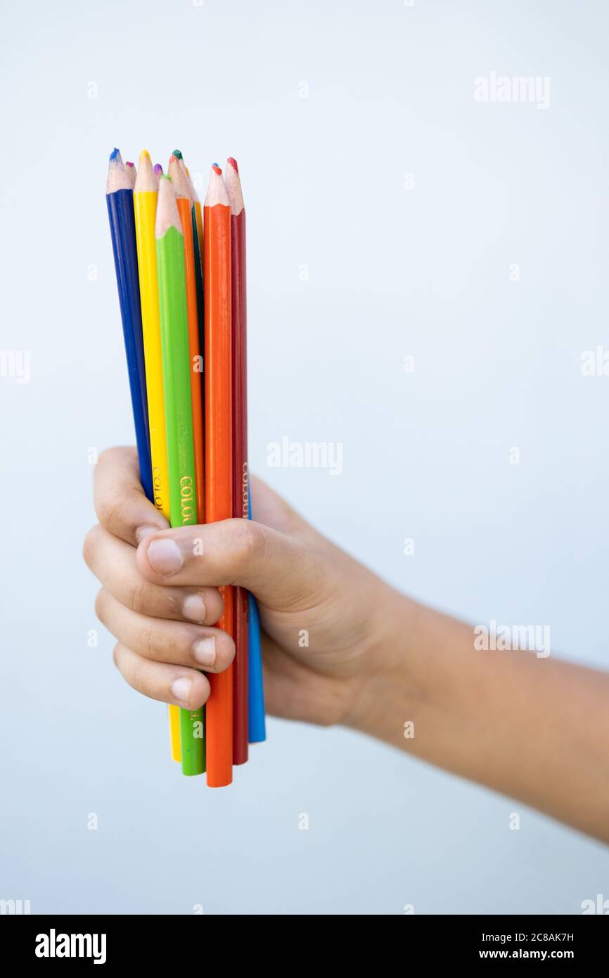 Child holding colorful drawing pencils on a white background Stock ...
