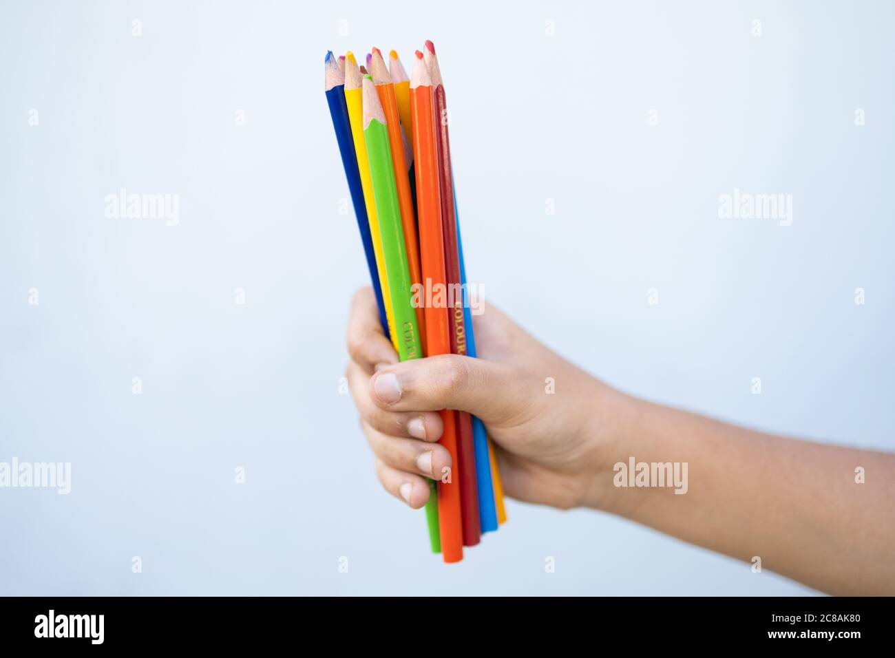 Child holding colorful drawing pencils on a white background Stock ...
