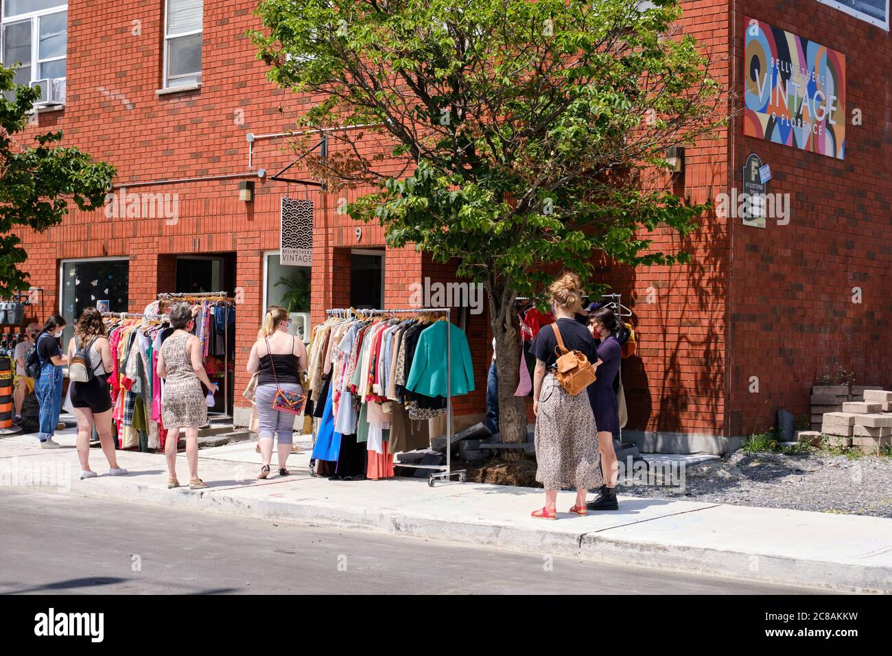 People lined up around clothing rack display outdoors of Vintage shop ...