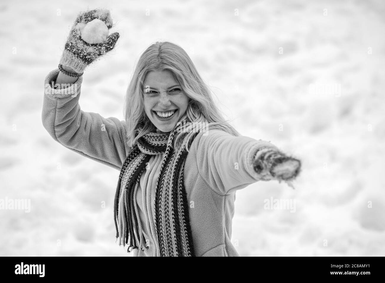 Girl in mittens hold snowball. Happy young girl playing snowball fight ...
