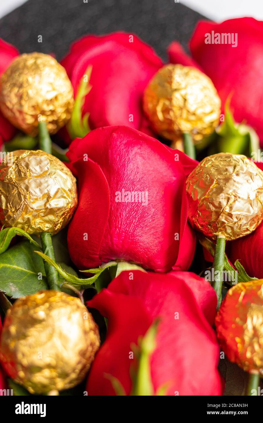 Bouquet of red roses with golden chocolates Stock Photo - Alamy