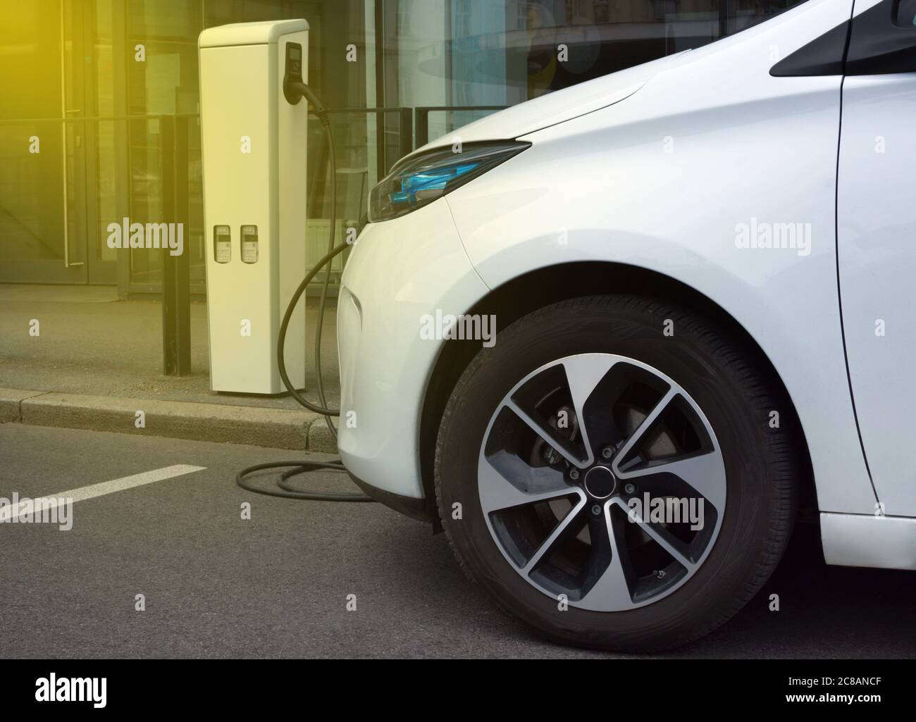 Modern electric car plugged in charging on the street station. New ...