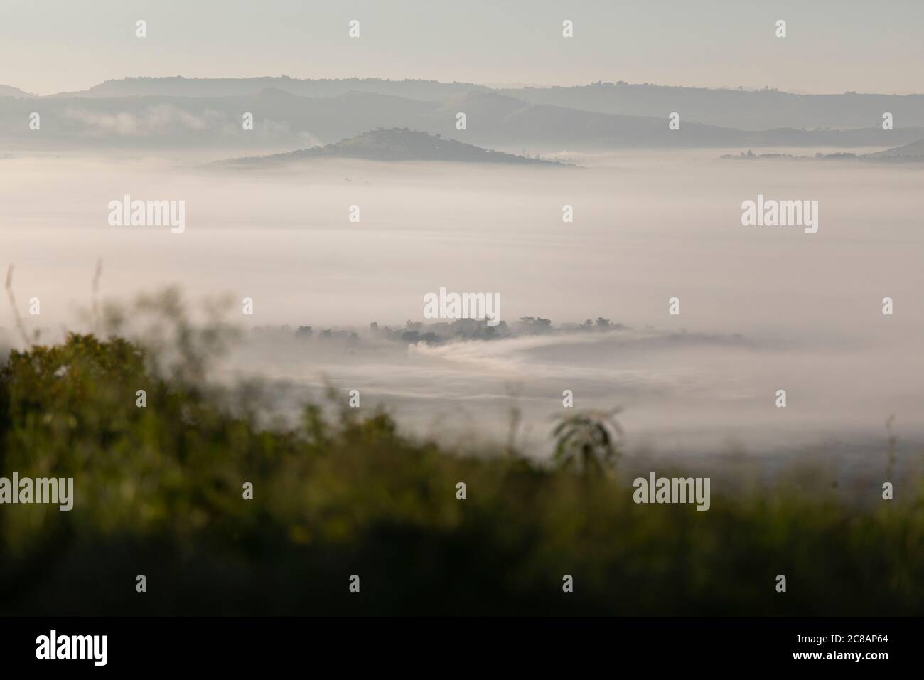 Fog envelops a valley beneath rolling hills and communities of ...
