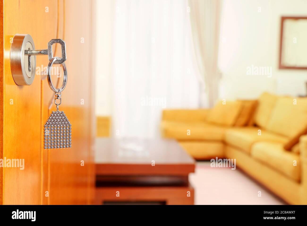 open door with key in keyhole and living room in the background Stock ...