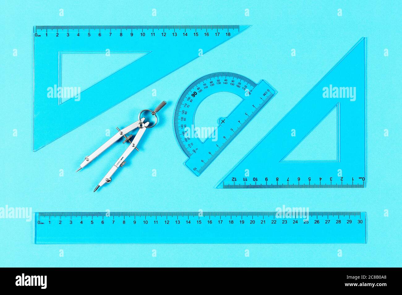 transparent rulers, protractor and compasses on blue surface Stock ...