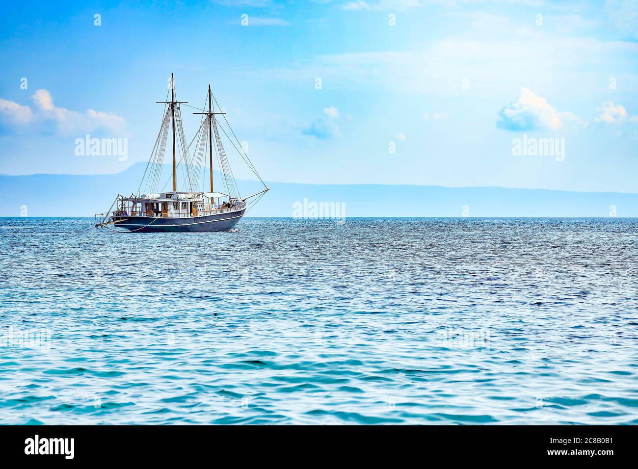 sailboat on a clam sea with blue sky Stock Photo - Alamy