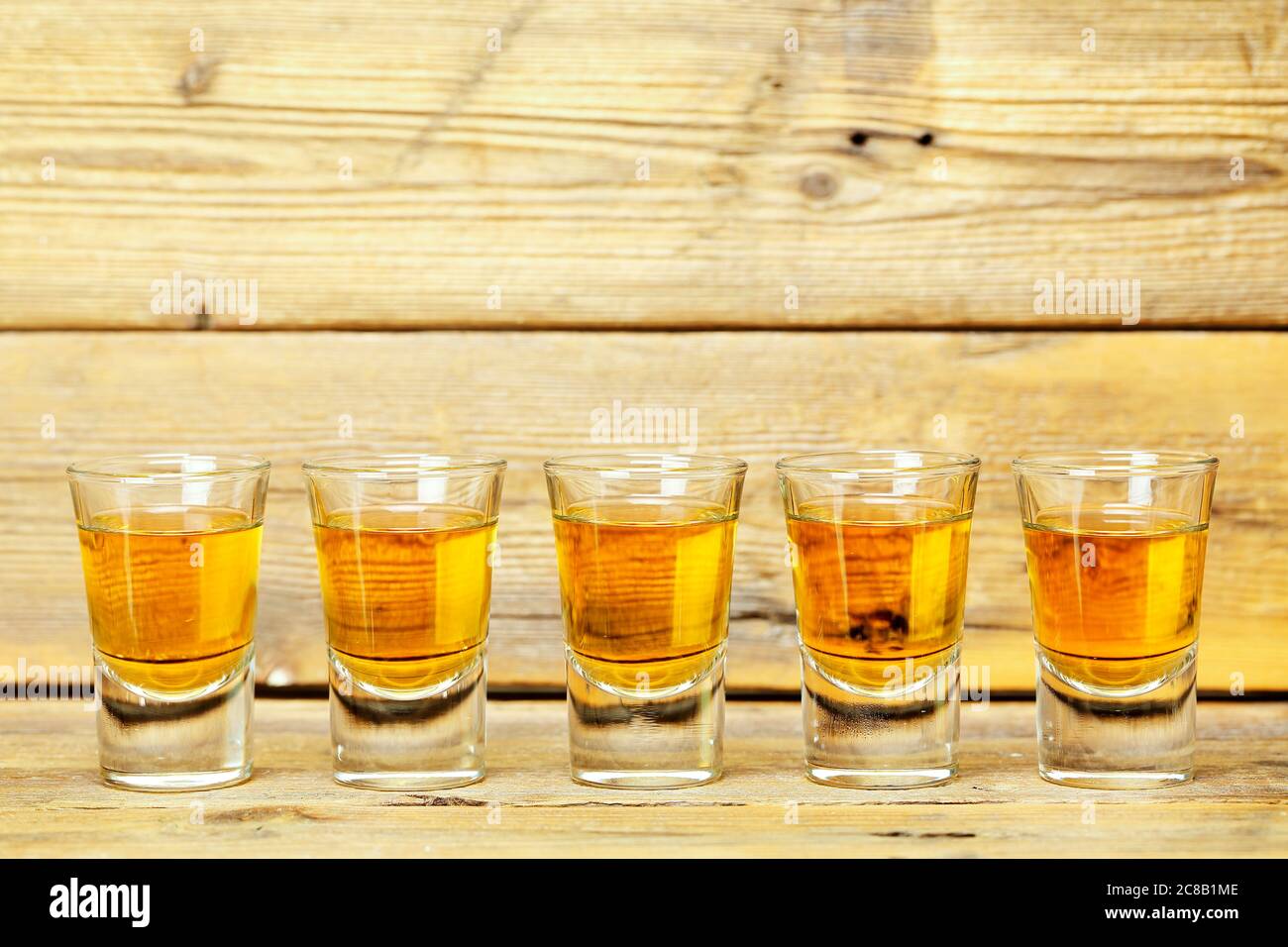 five whiskey shots on weathered wooden planks Stock Photo - Alamy