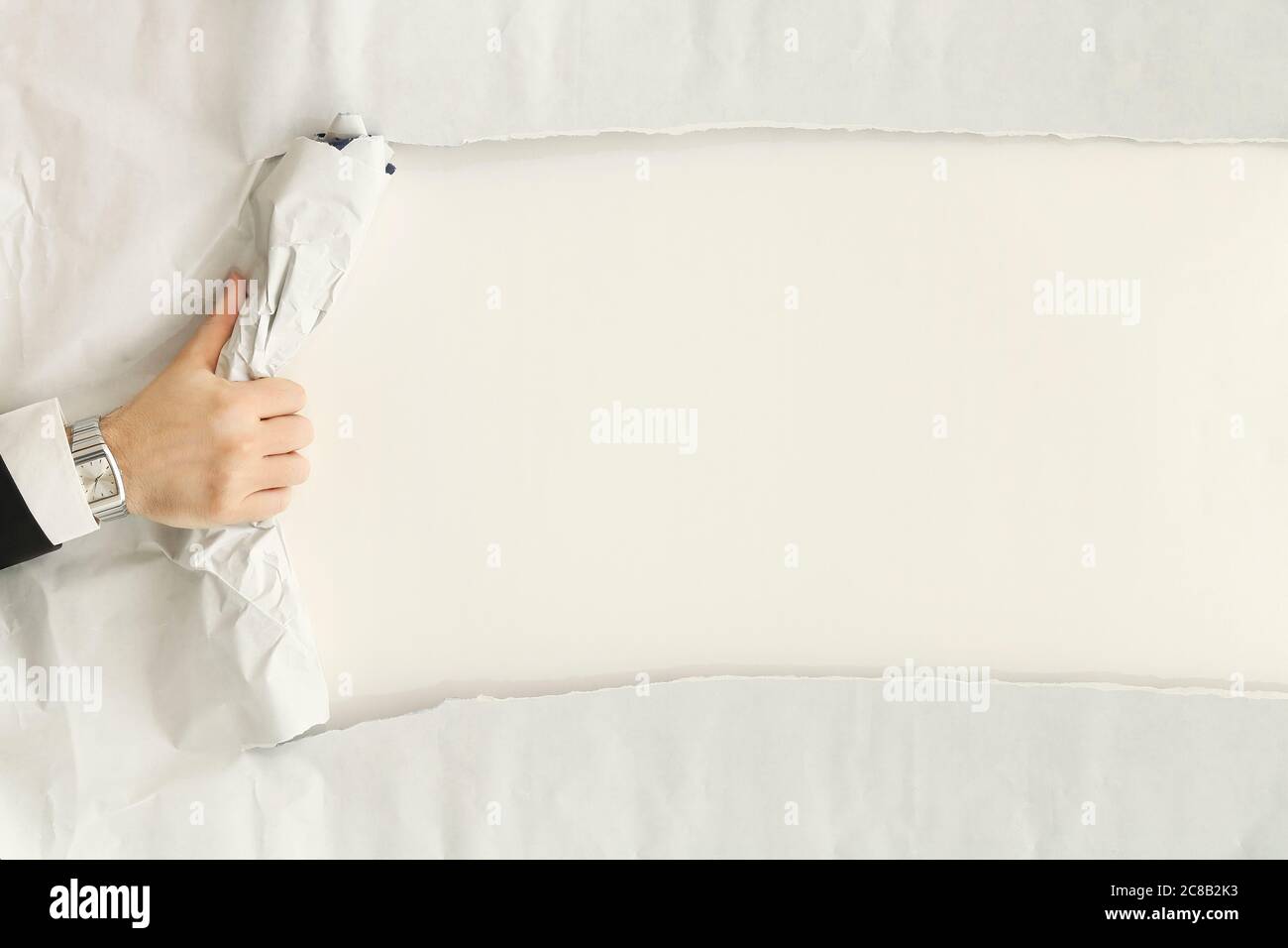 male hand ripping a paper sheet revealing a blank white surface Stock ...
