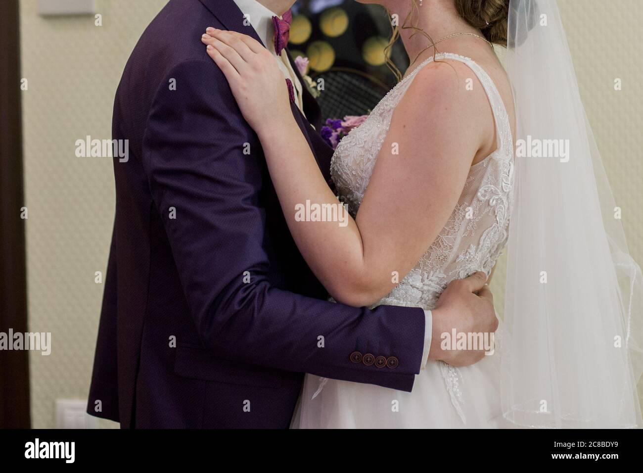a bride and groom hugging in the room Stock Photo - Alamy