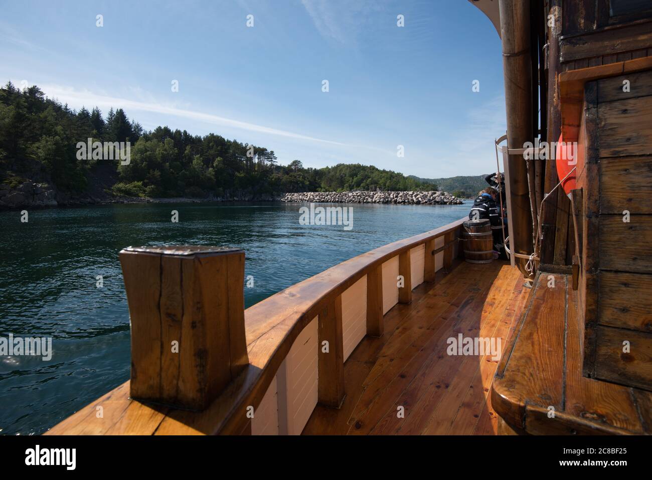 Railing of an old wooden fishing boat passing through a narrow sound ...