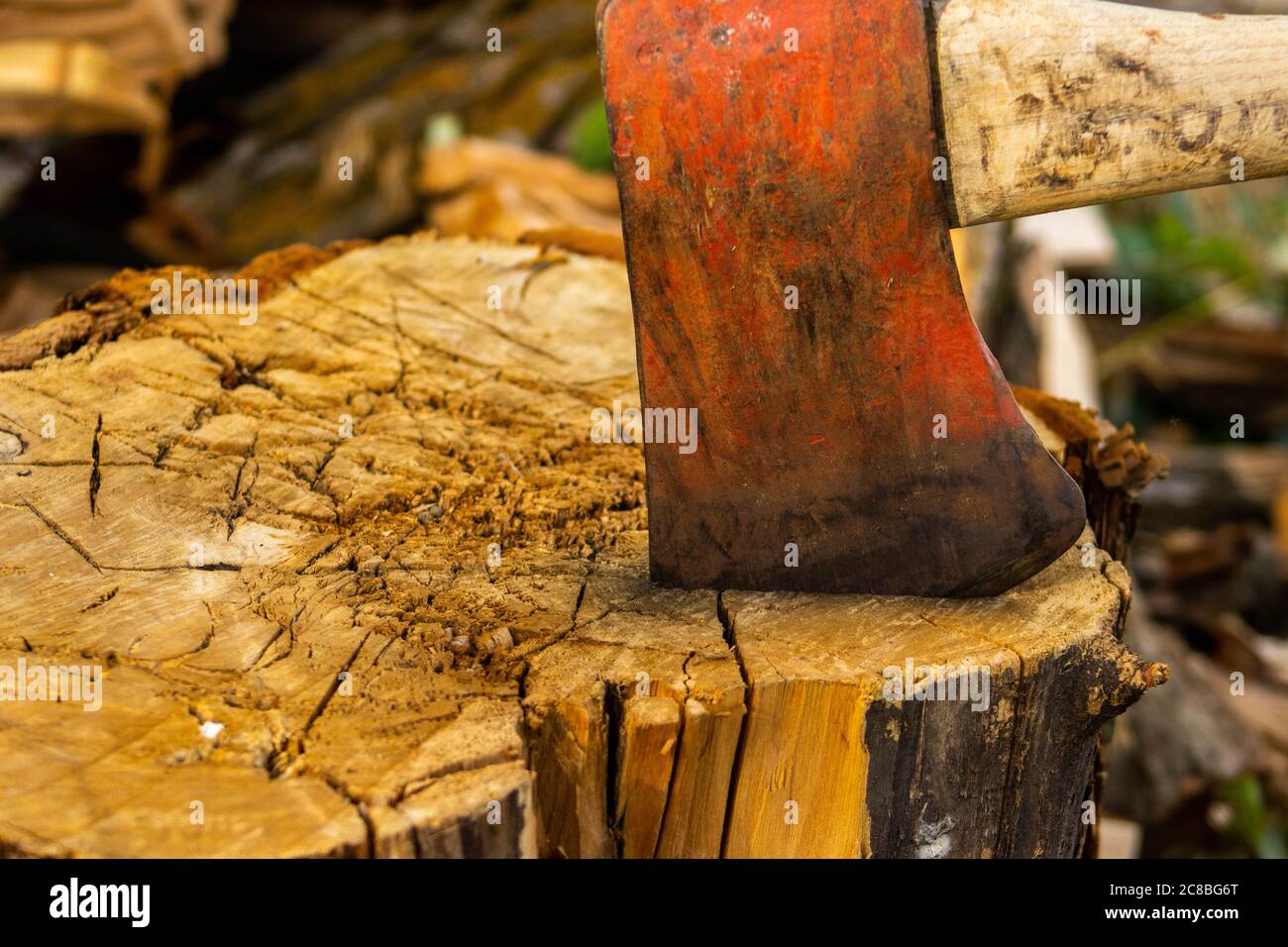 Rusty red ax stuck into a tree stump Stock Photo - Alamy