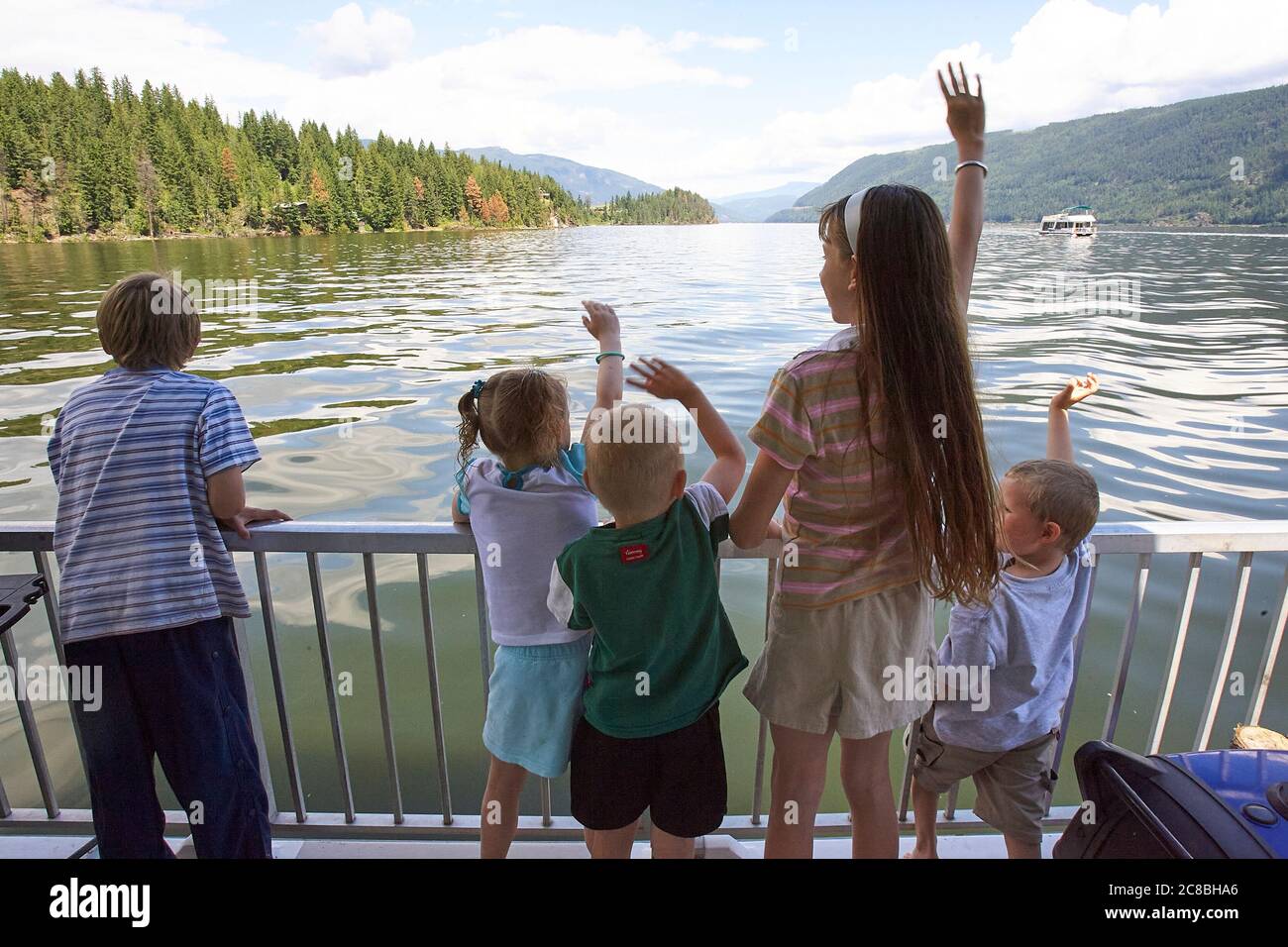 Kids looking over railing on houseboat looking at the view Stock Photo ...