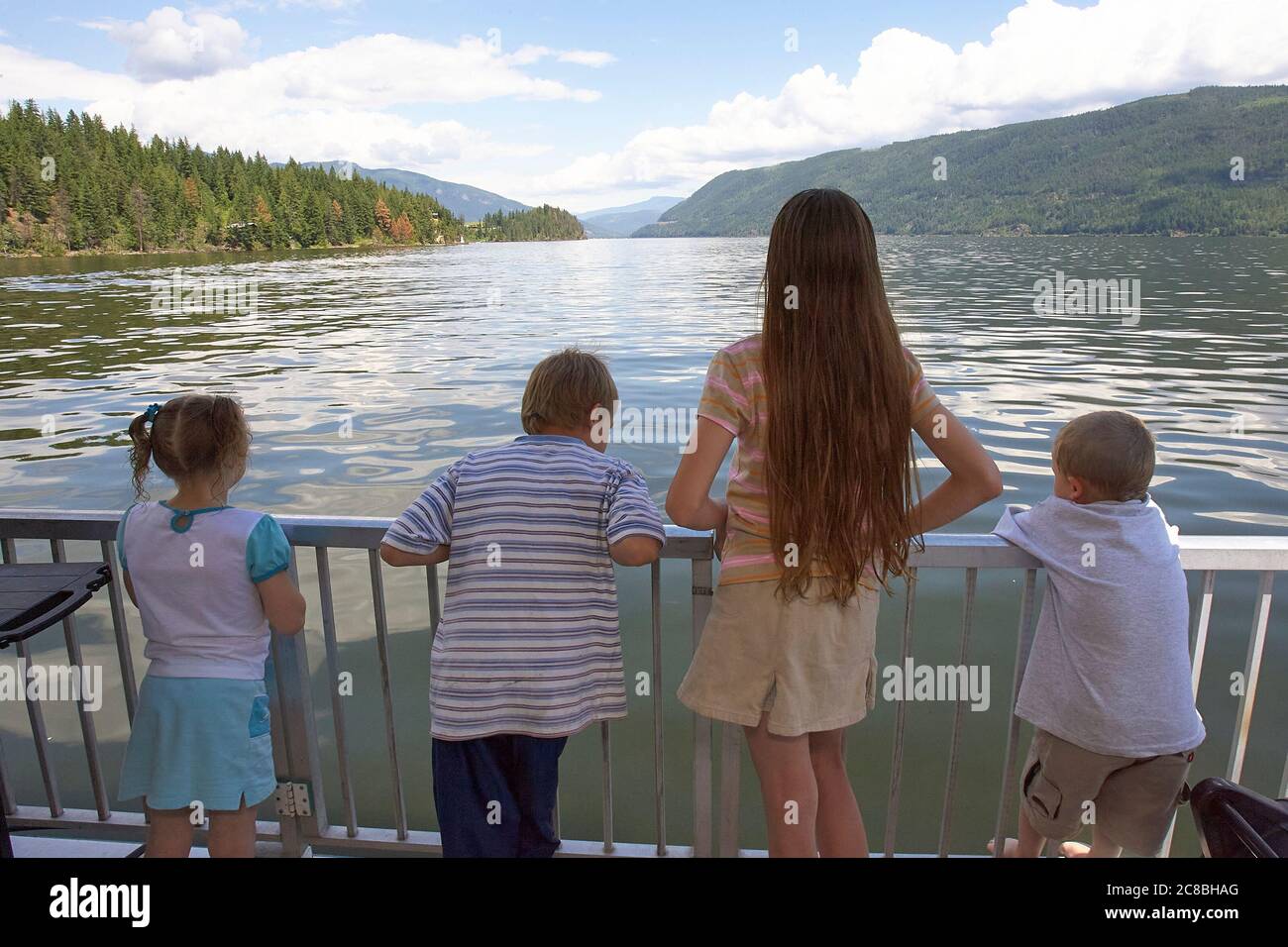 Kids looking over railing on houseboat looking at the view Stock Photo ...
