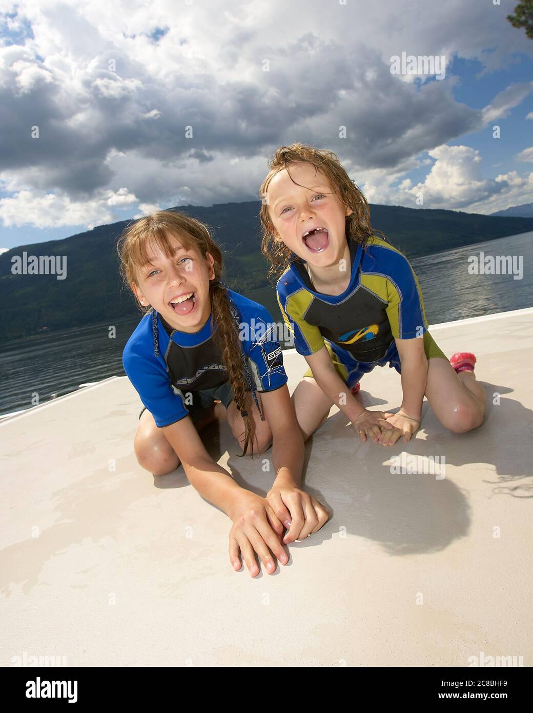 Two young girls laughing on houseboat deck Stock Photo - Alamy