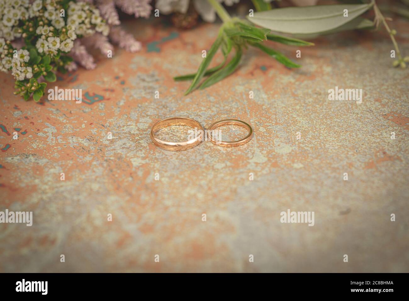 Wedding rings in gold on a rusty table Stock Photo - Alamy