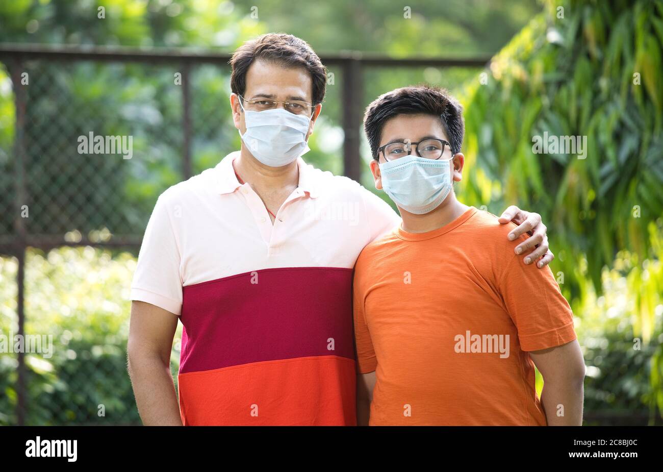 Father and son with protective face mask looking at camera Stock Photo ...
